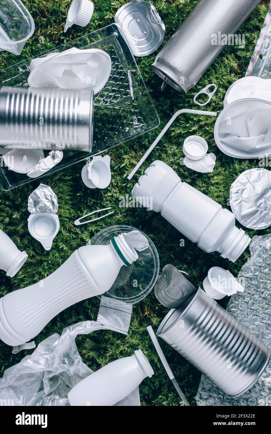 Food plastic packaging, trash on green moss background after picnic in ...