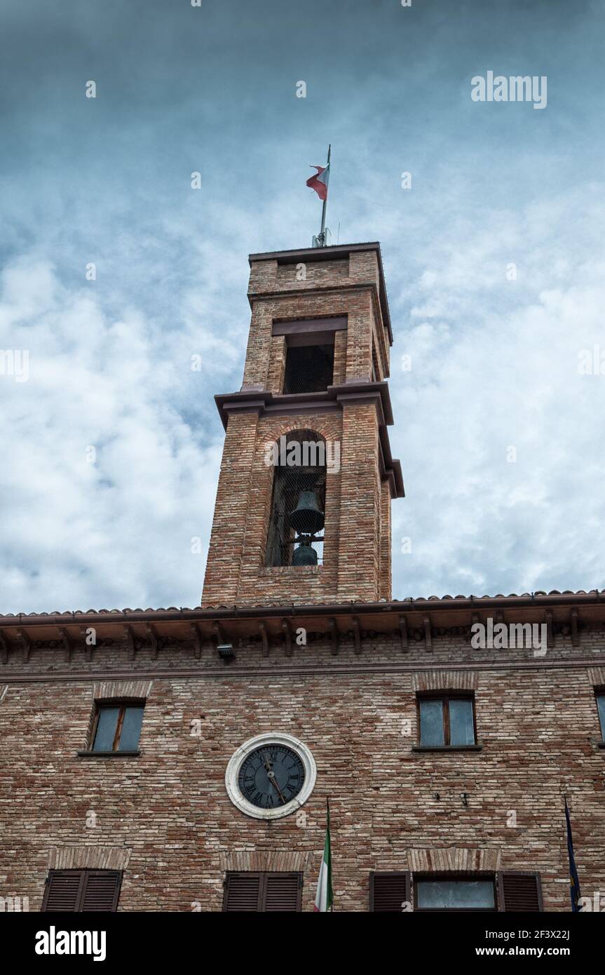 A vertical low angle shot of Italy flag on bell tower under a gloomy ...