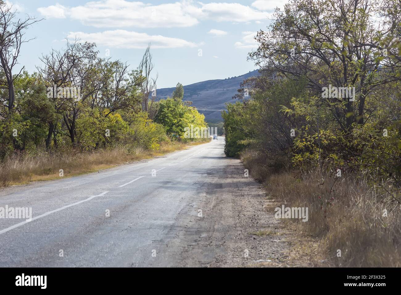 Country single-lane road and mountainous background Stock Photo - Alamy