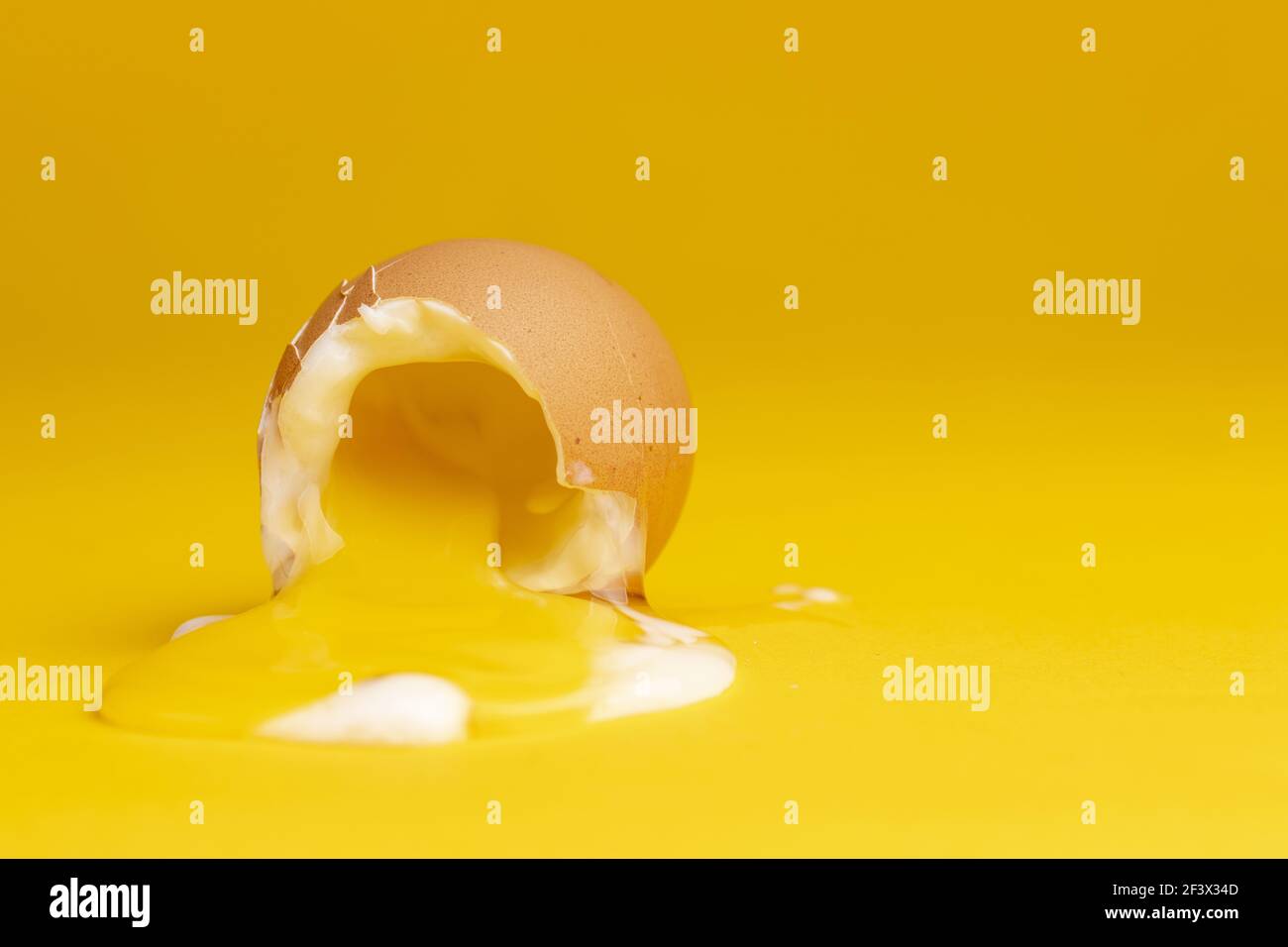 Spilling of fallen over broken shell of soft cooked egg with the slimy ...