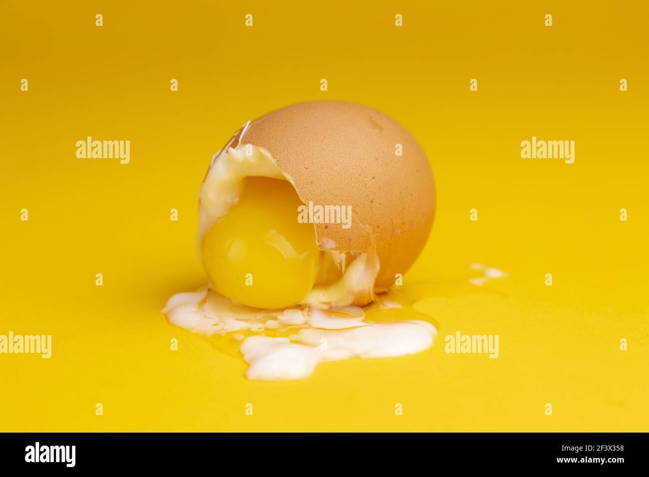 Yolk spilling out broken shell of soft cooked egg with the slimy white ...