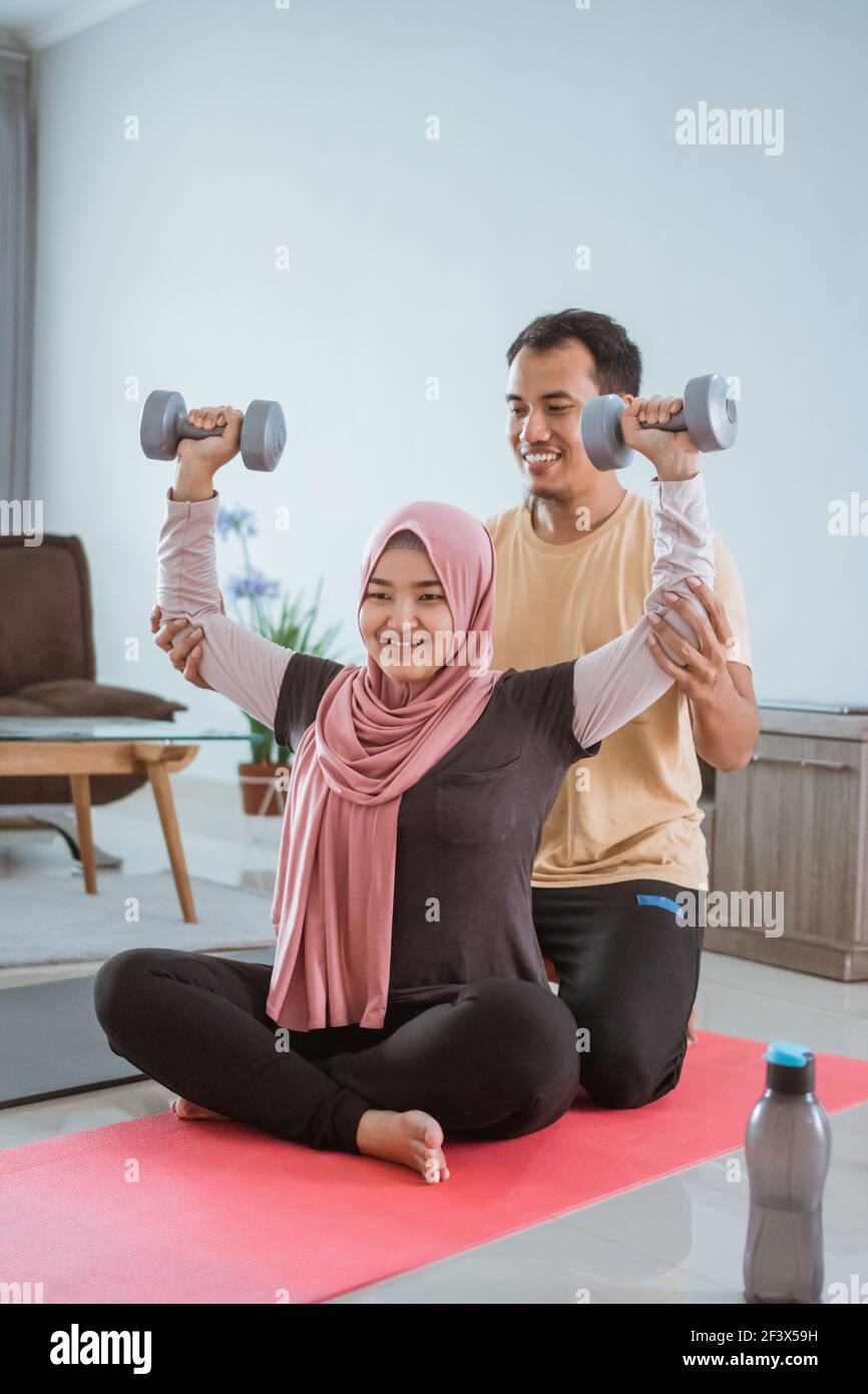 asian muslim couple exercising and lifting weight at home Stock Photo ...