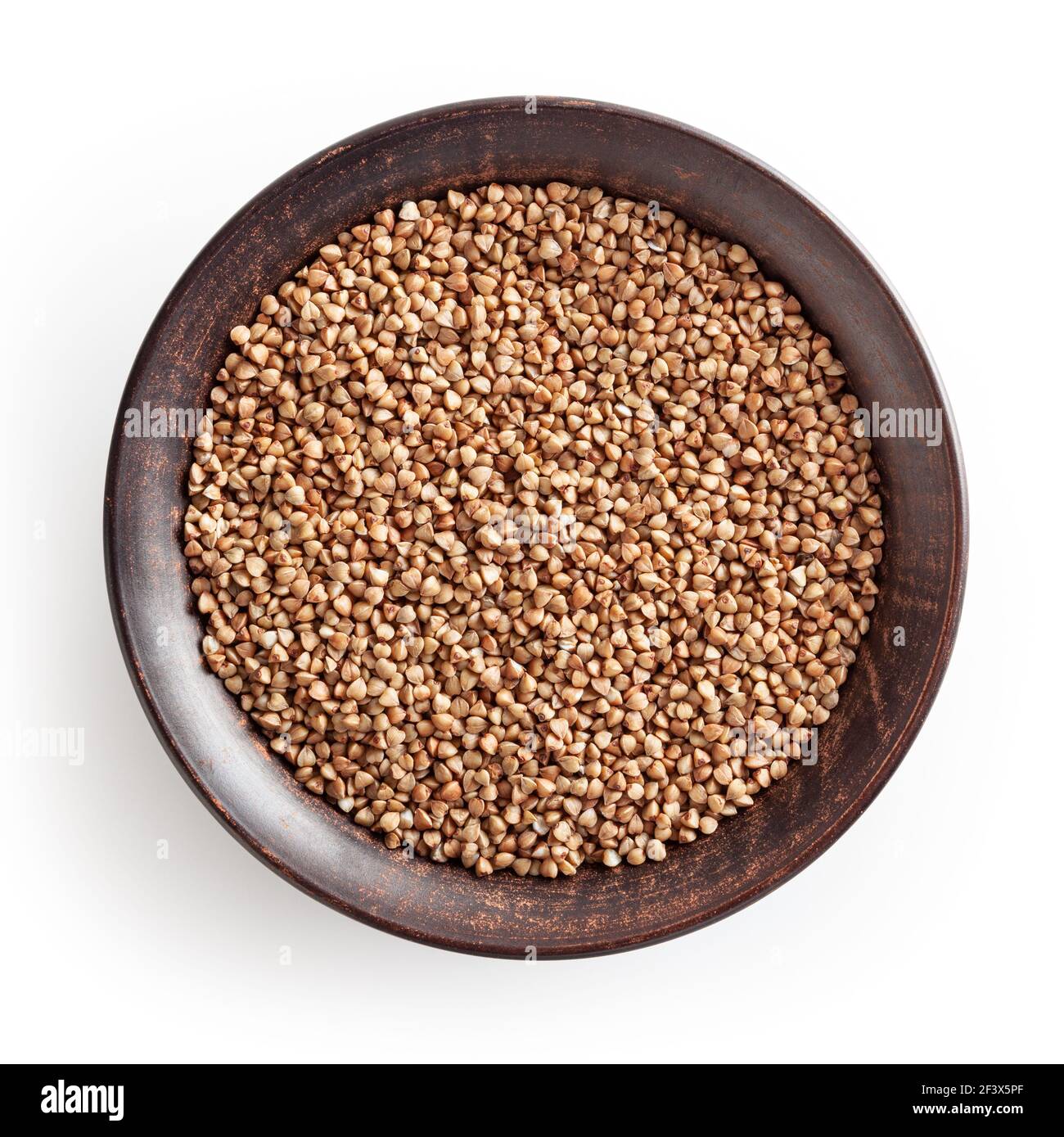 Uncooked roasted buckwheat in ceramic bowl isolated on white background ...