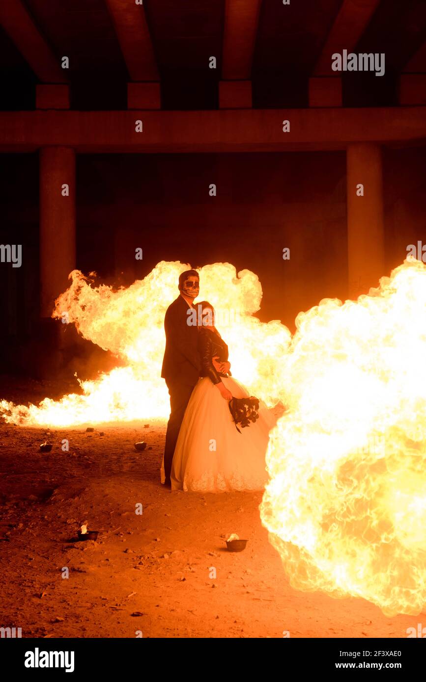 Halloween couple standing with flamethrower. big fire Stock Photo - Alamy