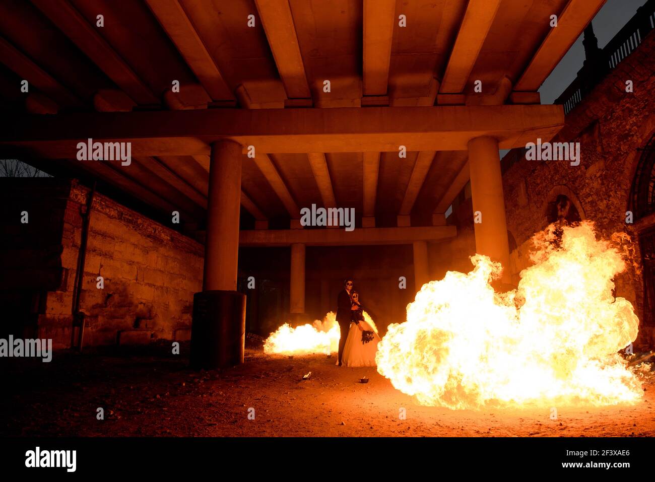 Halloween couple standing with flamethrower. big fire Stock Photo - Alamy