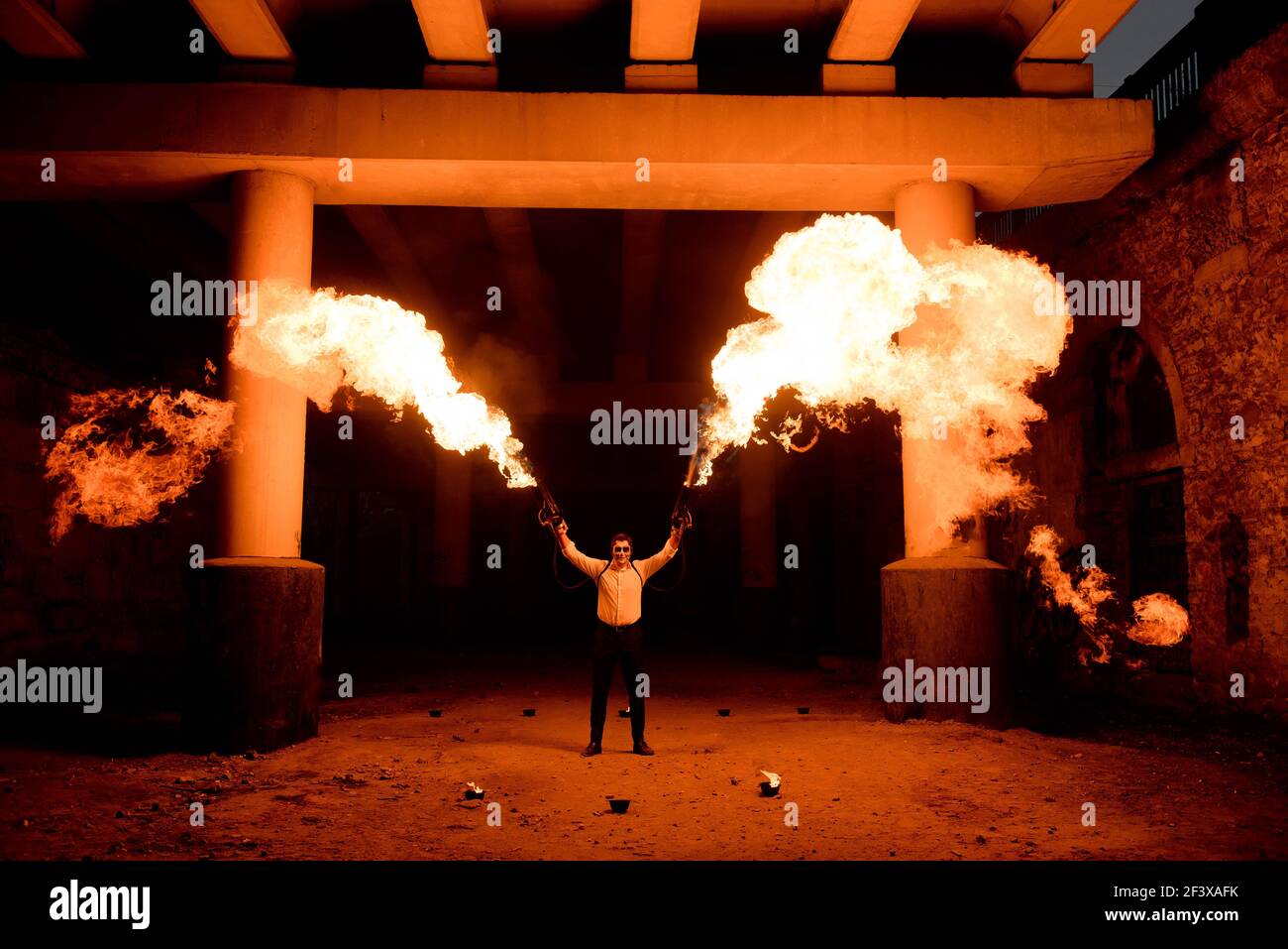 Halloween man in costume with flamethrower in his hands. Devil makeup ...