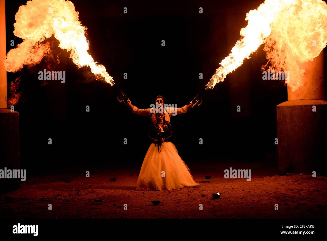 Halloween couple standing with flamethrower in hands. big fire Stock ...