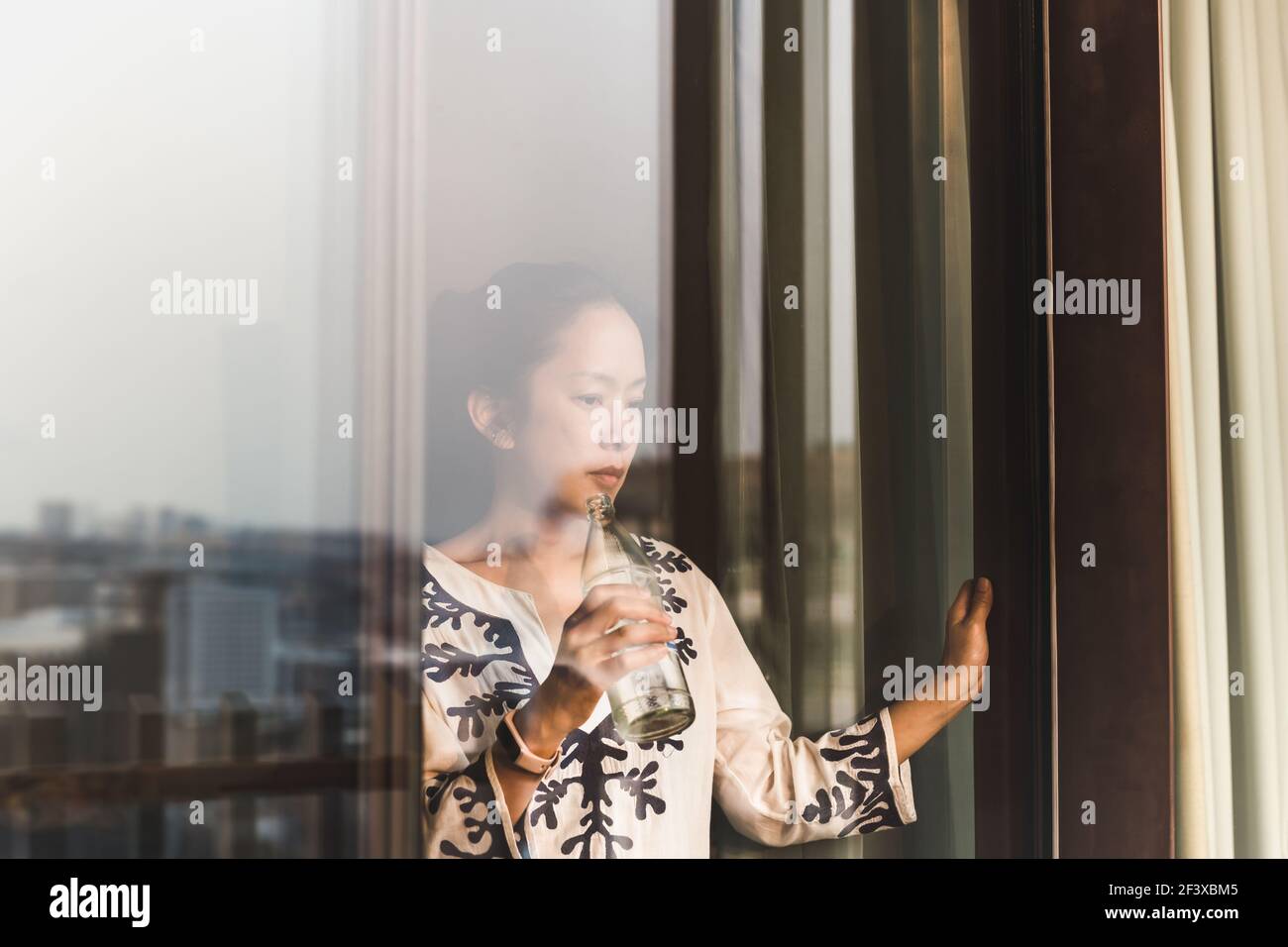 Shot through window woman relaxing holding botttle of water Stock Photo ...