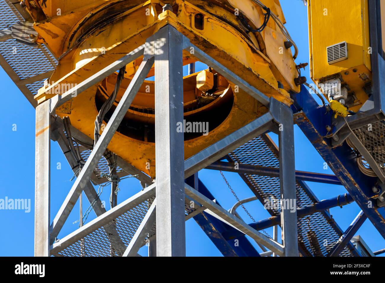 Closeup top of construction tower crane, showing yellow and grey steel ...