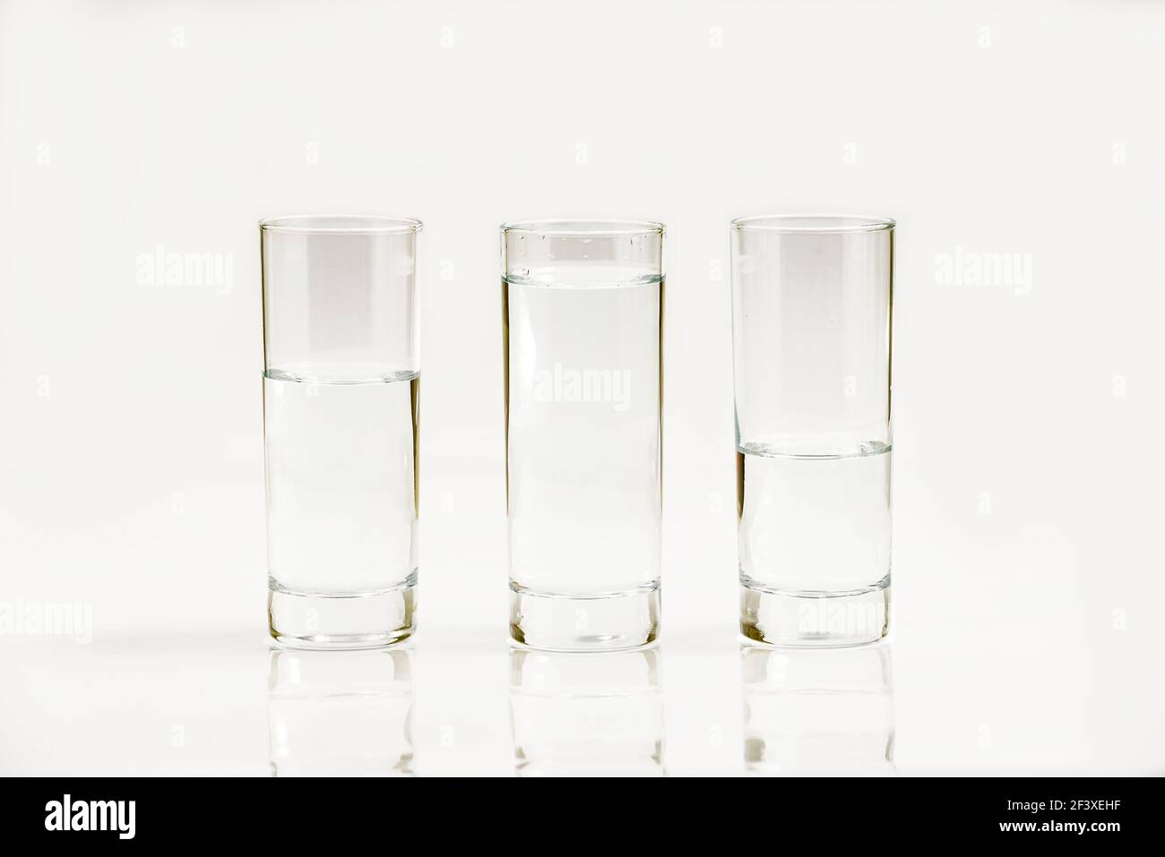 Water in three glasses - different level, isolated over a white ...
