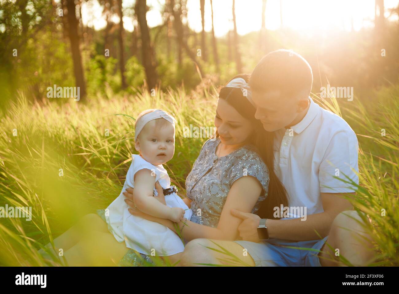 Happy family dad, mom playing in the fresh air on the field watching ...