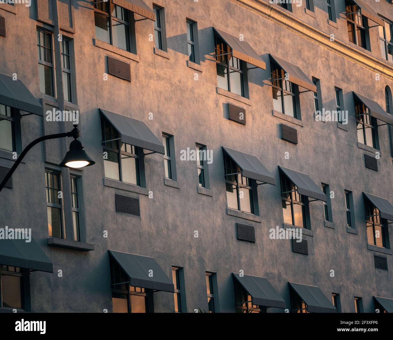 A vertical of a beautiful contemporary gray high rise building gleaming ...