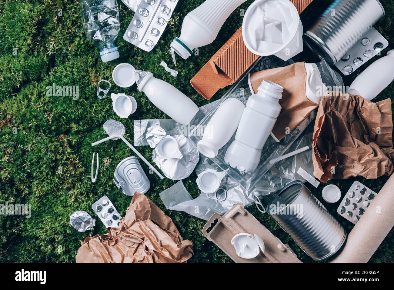 Food plastic packaging, trash on green moss background after picnic in ...