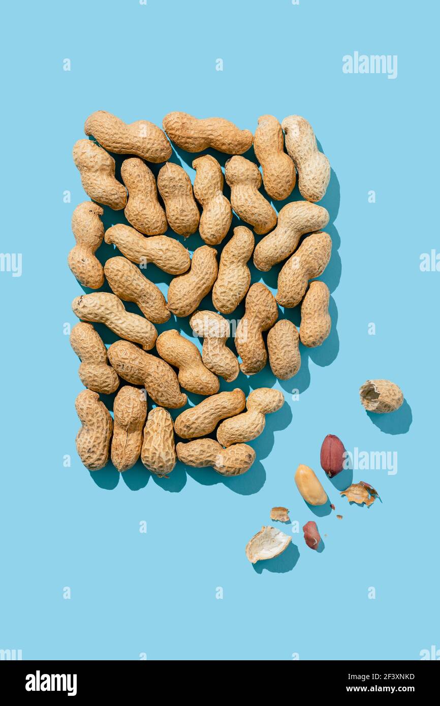 Peanuts on a blue background Stock Photo - Alamy