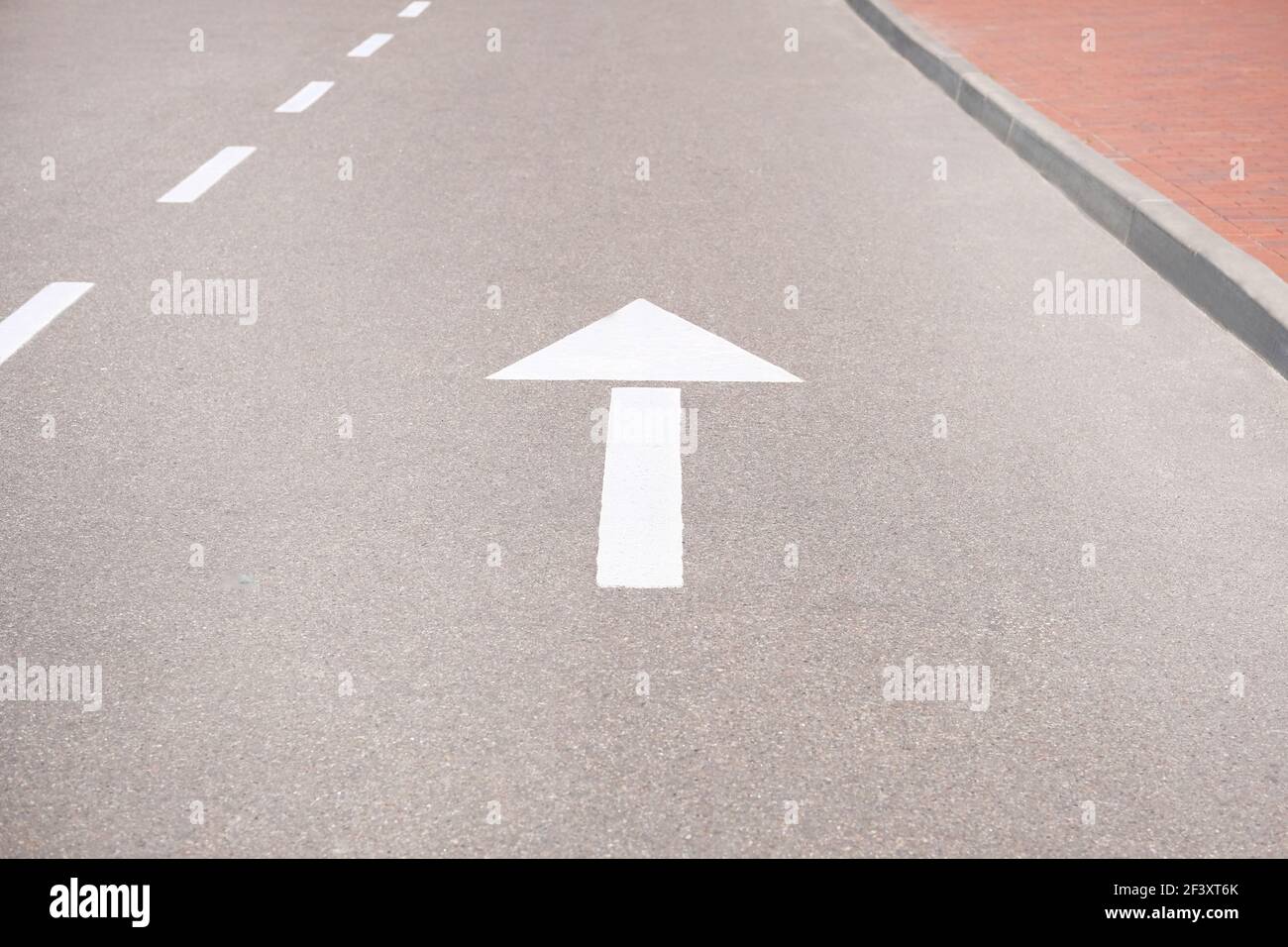 Forward signs on the road. White arrow marking pointing ahead on ...