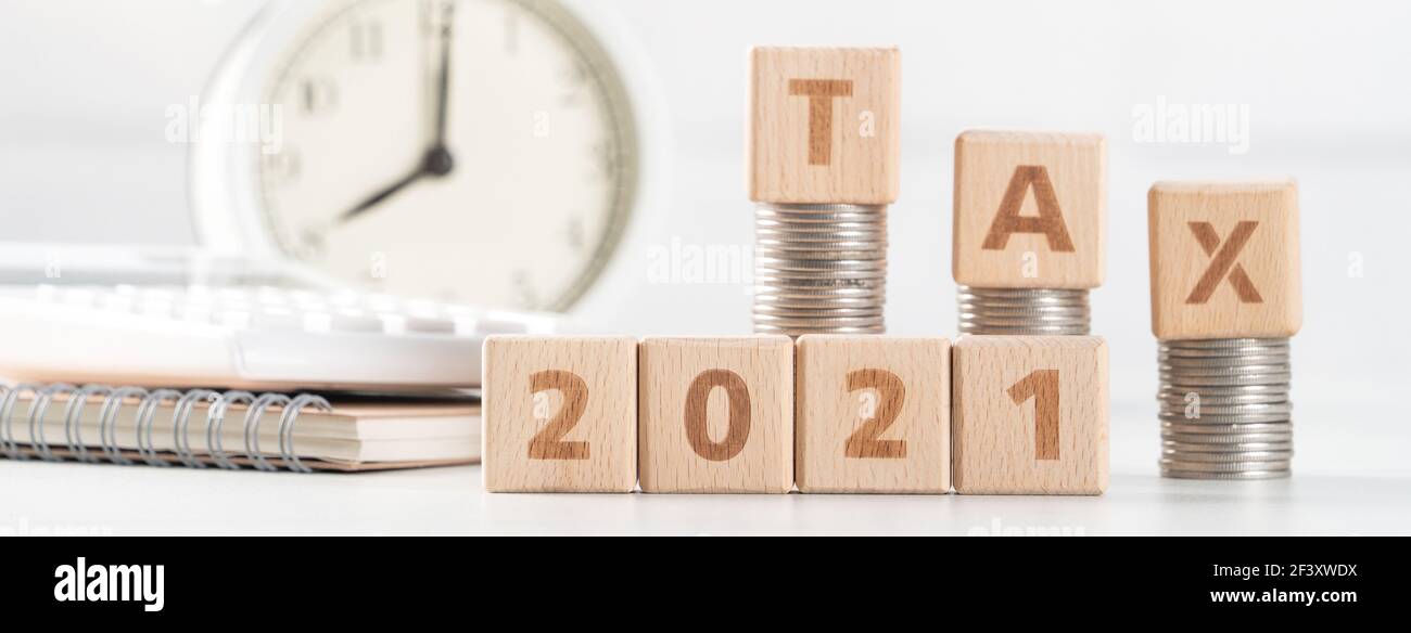 Concept of tax season approaching with wooden blocks, coins and alarm ...