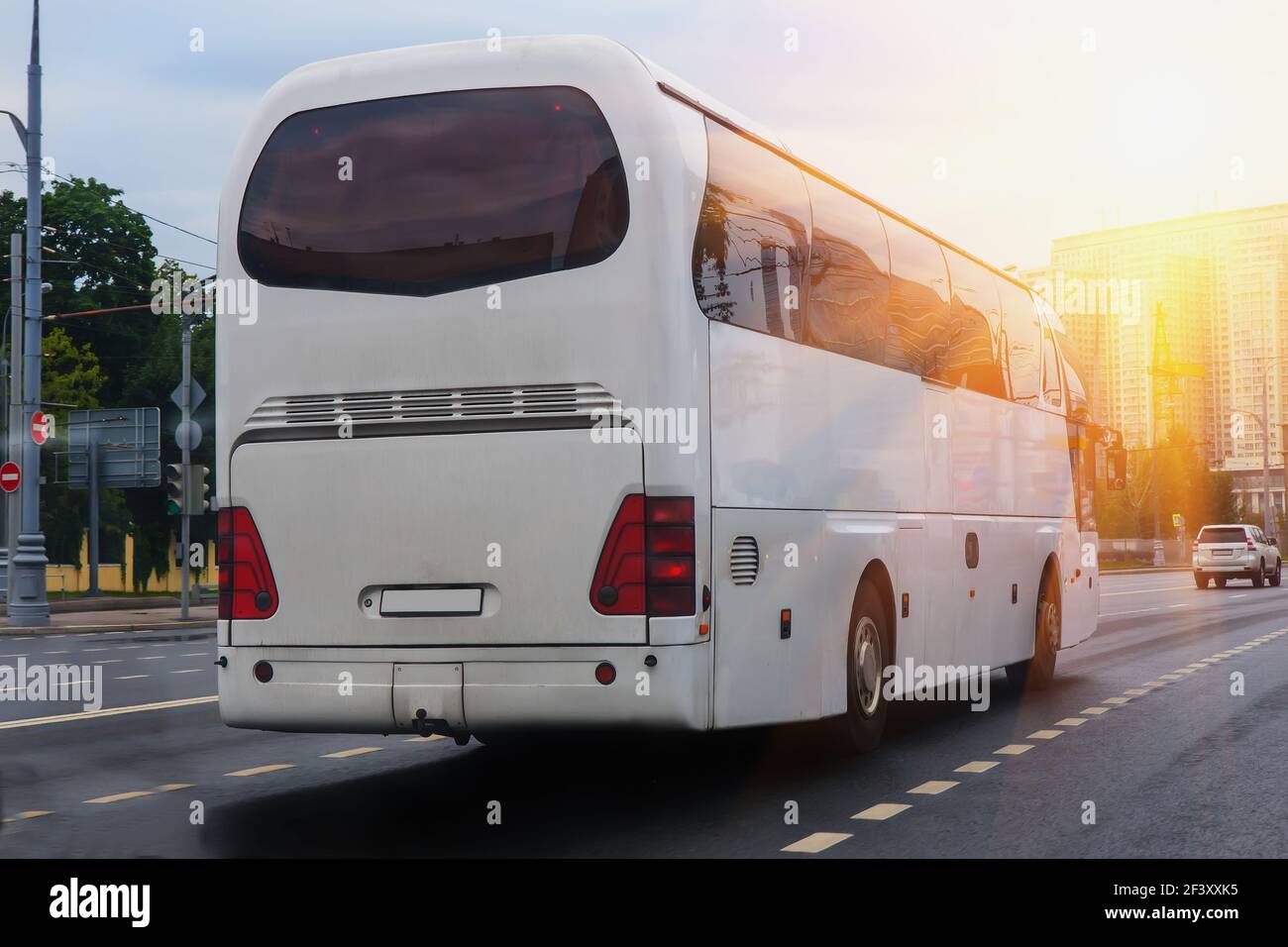 white tourist bus goes on the city street Stock Photo - Alamy