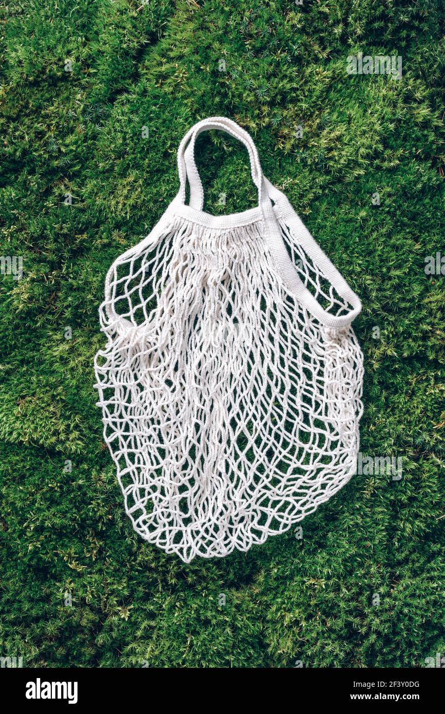 Reusable net bag or mesh shopper on green grass, moss background. Zero ...