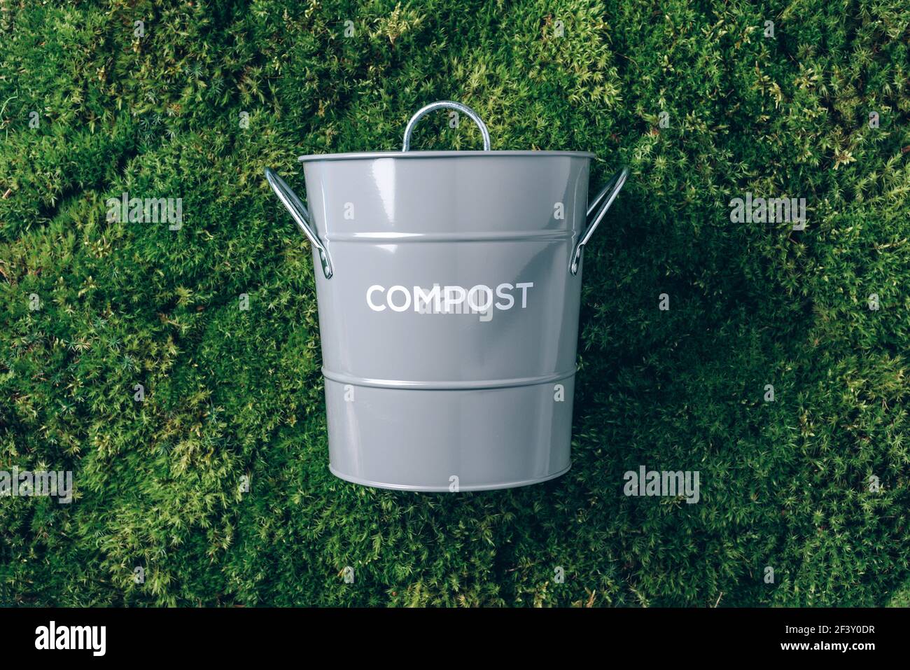 Trash bin for composting with leftover from kitchen on green grass ...