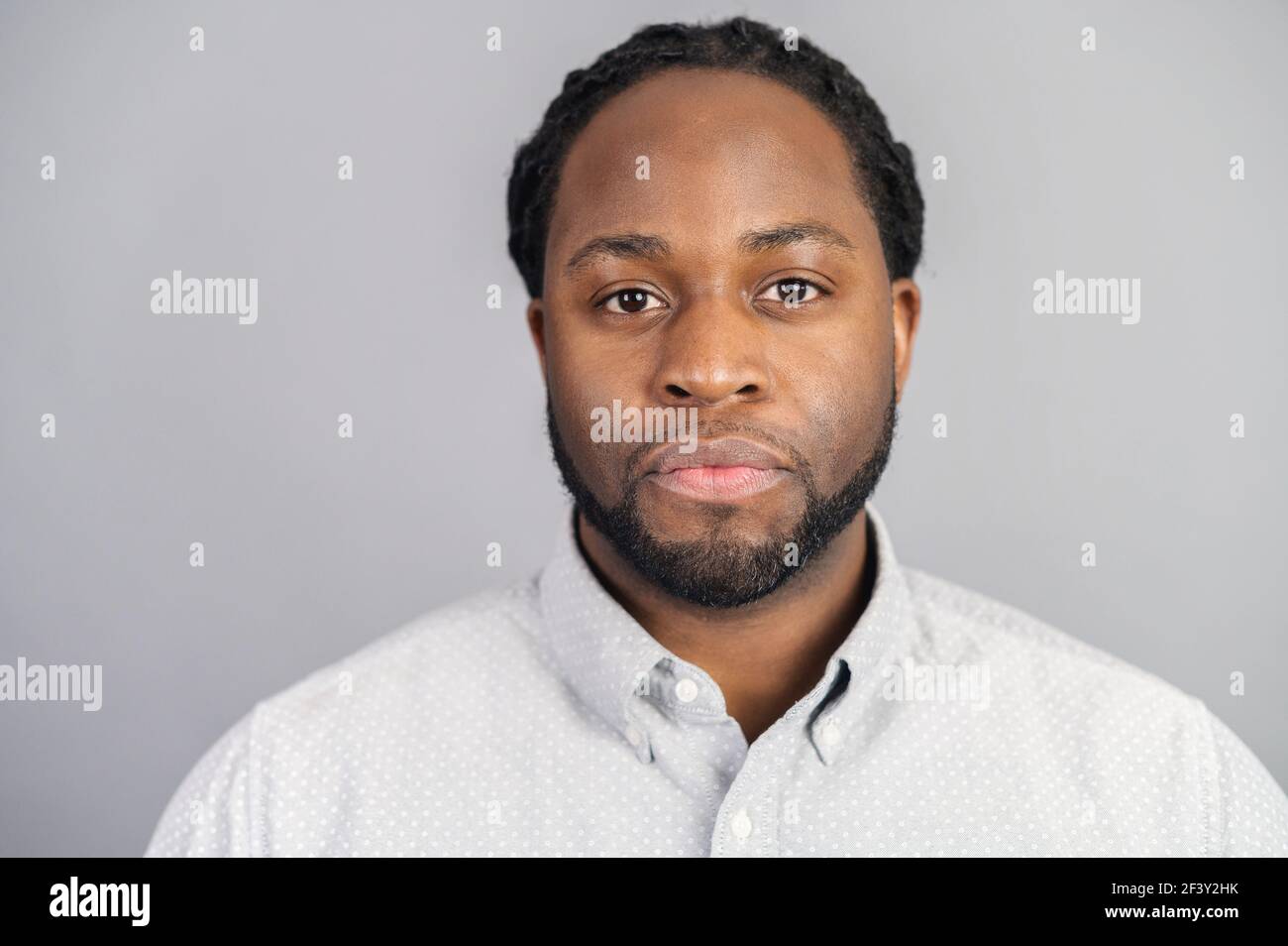 Serious and confident an African-American man staring at the camera, worried black guy looks ...