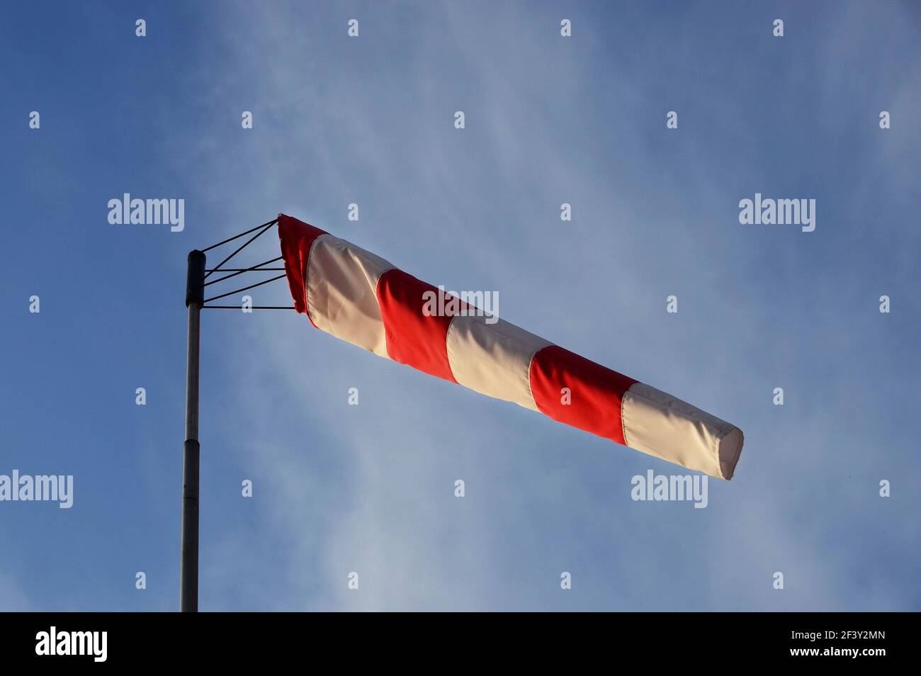 A wind cone weather vane on windy day with blue sky in the background ...