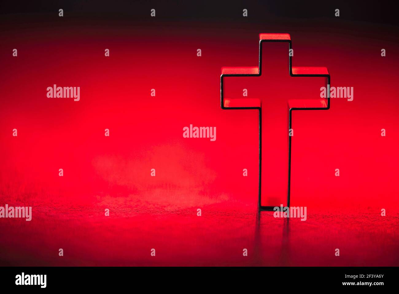 Silhouette of christian cross on red background, soft bokeh lights ...