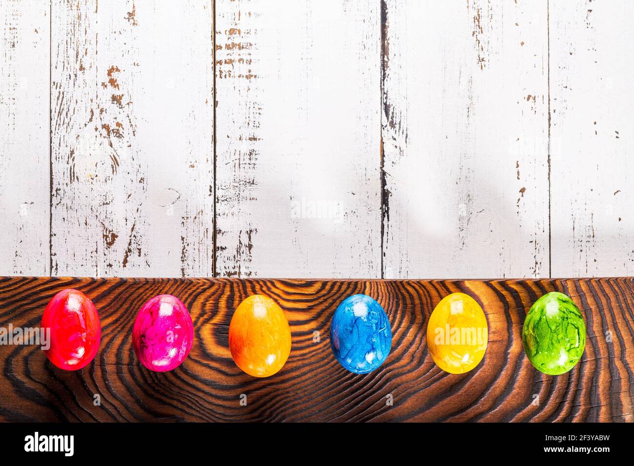 Easter wooden background with coloured eggs Stock Photo - Alamy