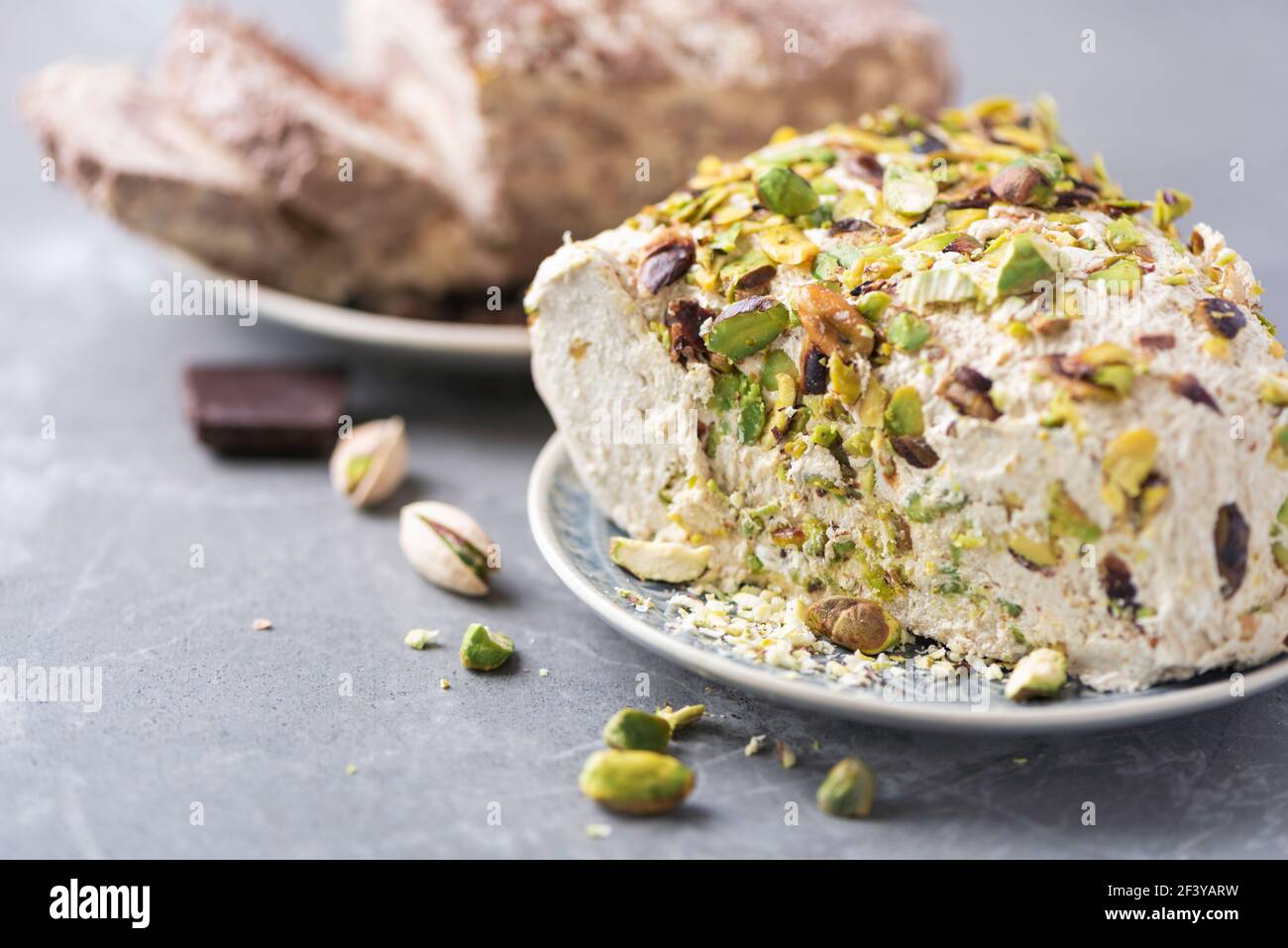 Sesame chocolate halva and halva with pistachios on grey background ...