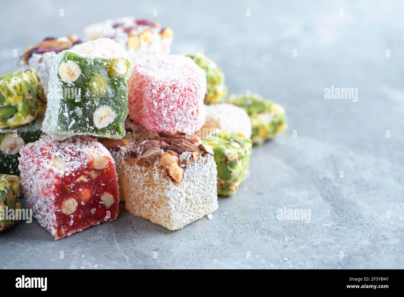 Turkish delight - lokum or rahat lokum with pistachios on grey ...