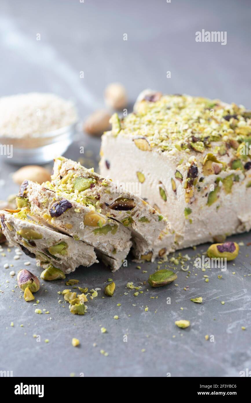 Sesame halva with pistachios on grey background. Top view. Copy space ...
