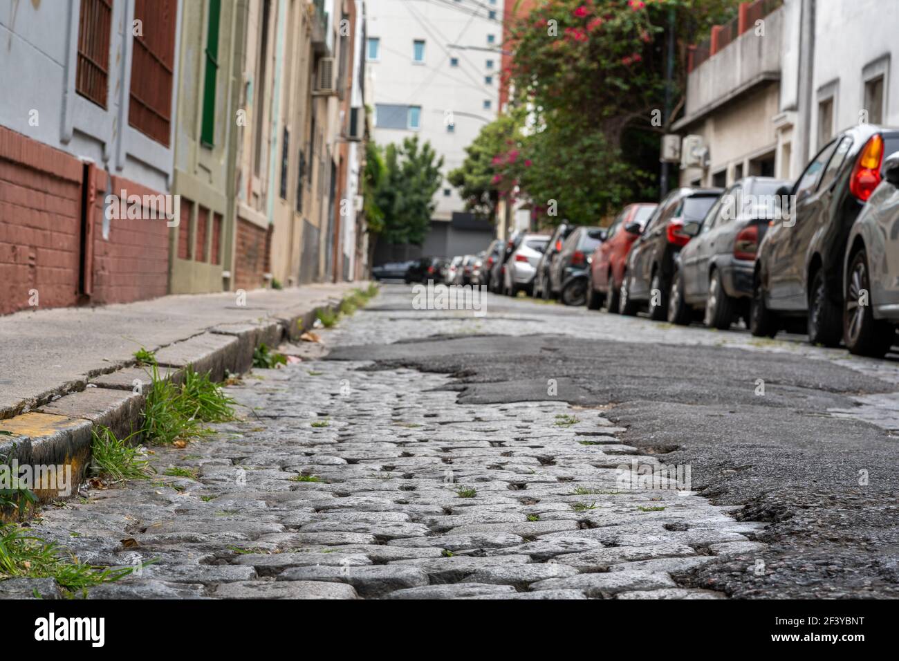 A pavement surface with a row of cars parked along the street Stock ...