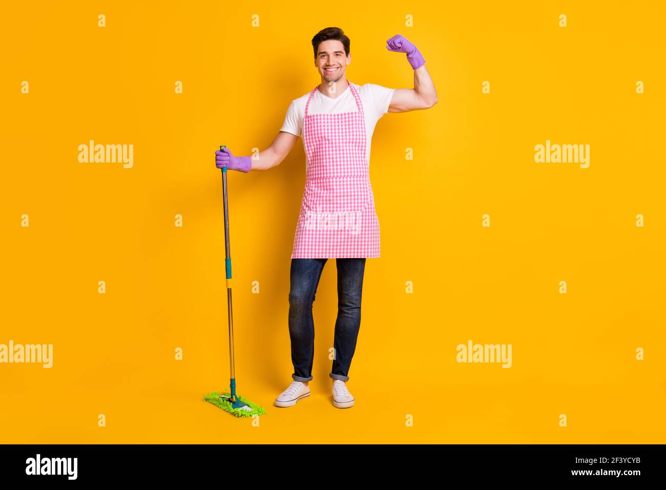 Full size photo of positive man arm flex biceps hold mop have good mood ...