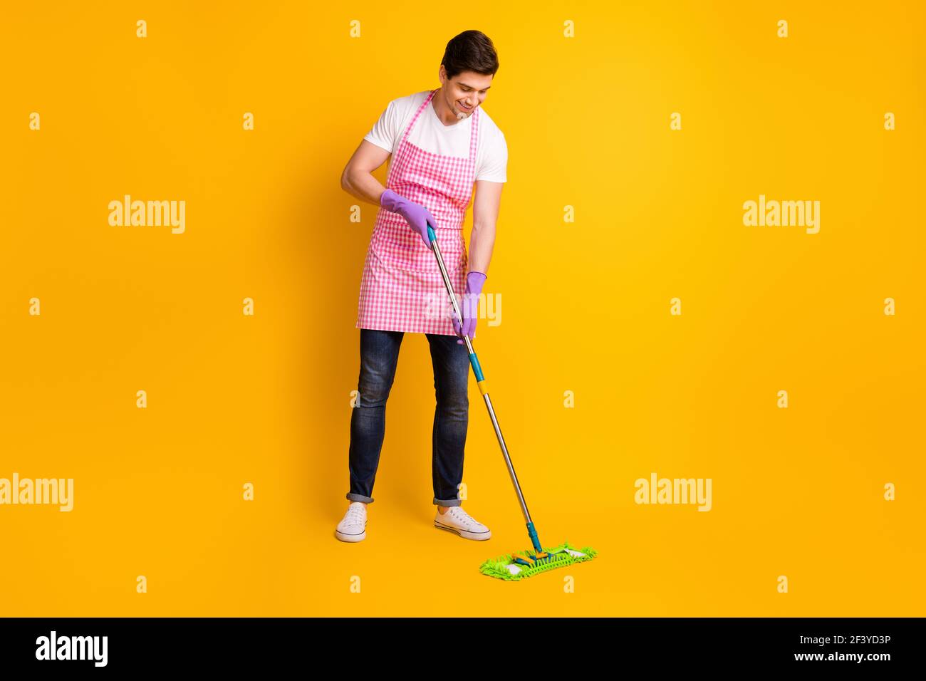 Full size photo of young happy positive good mood smiling man cleaning ...