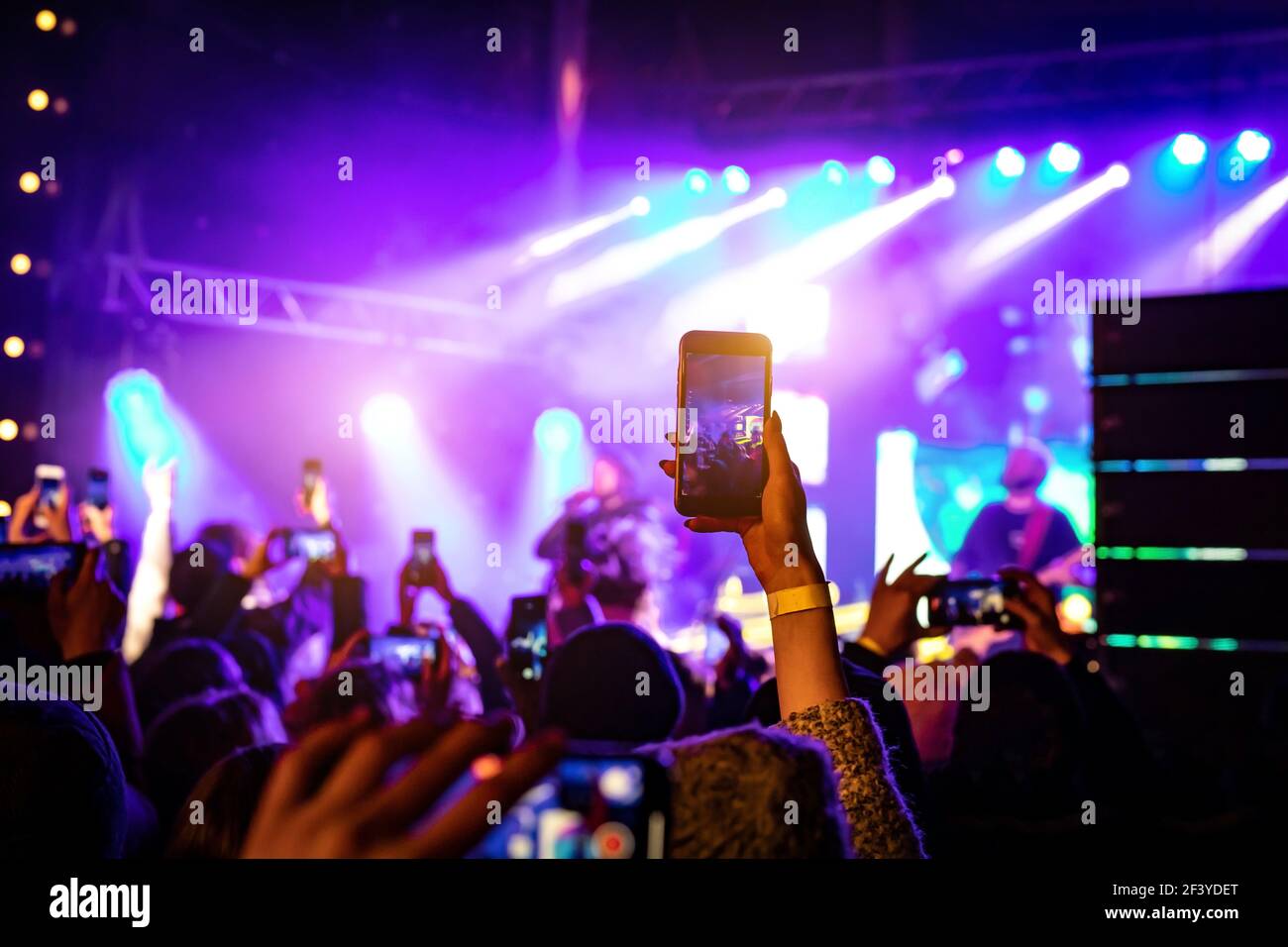 Recording a concert with mobile phone, silhouette of hands with ...