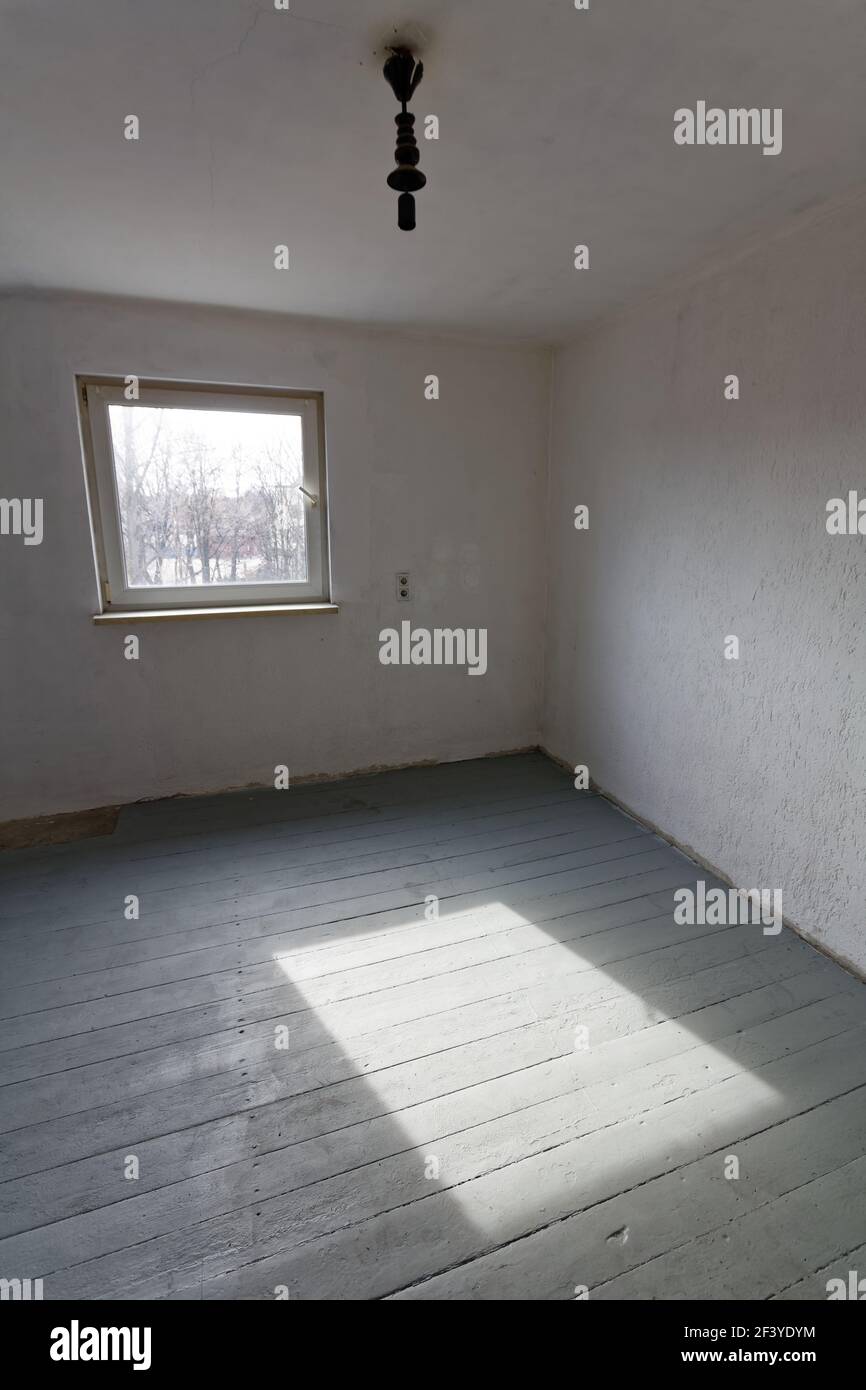 Empty white room of a studio with a window with a patch of light in the ...