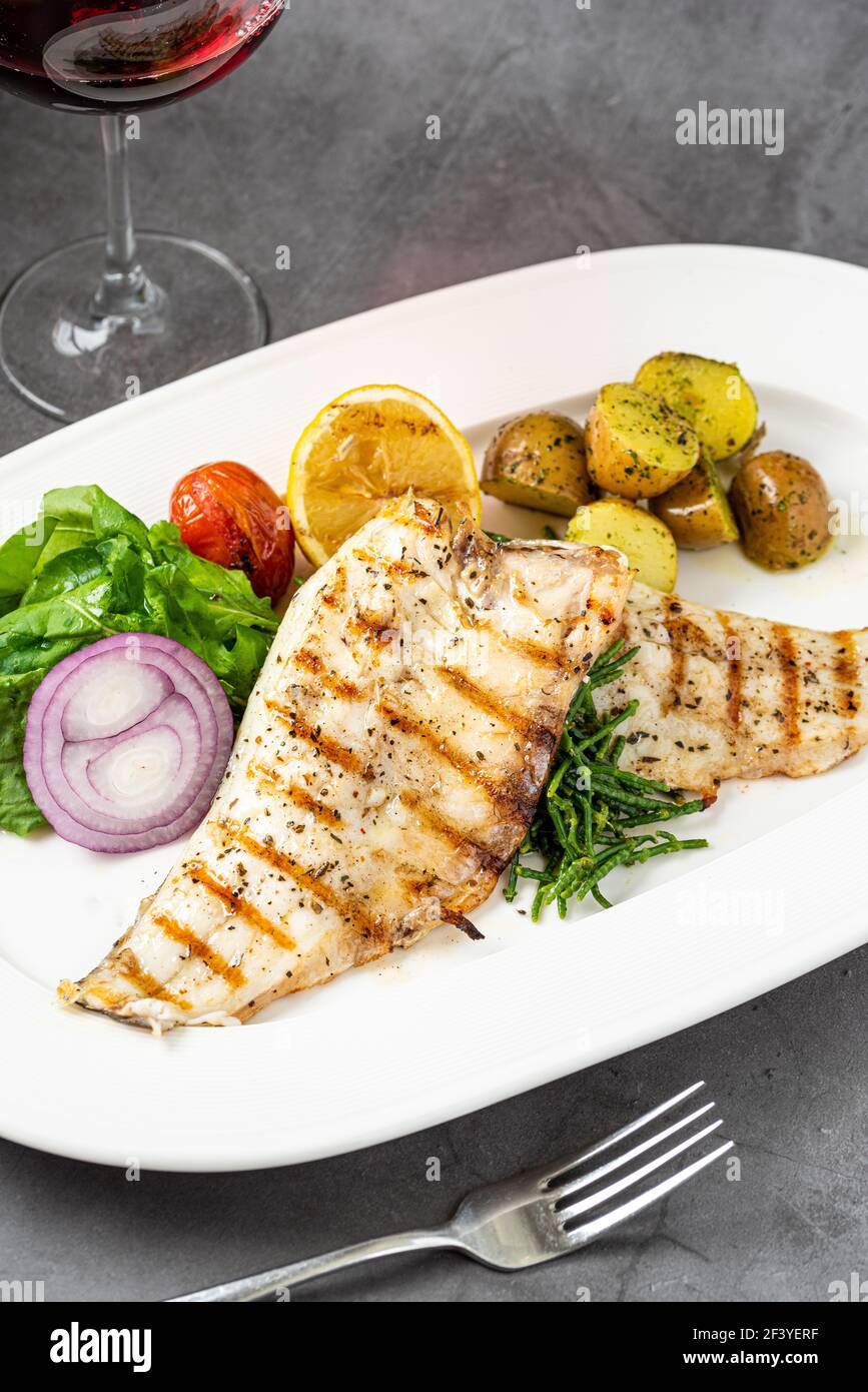 Grilled seabass fillet with garnish, seafood fish dish elegant ...