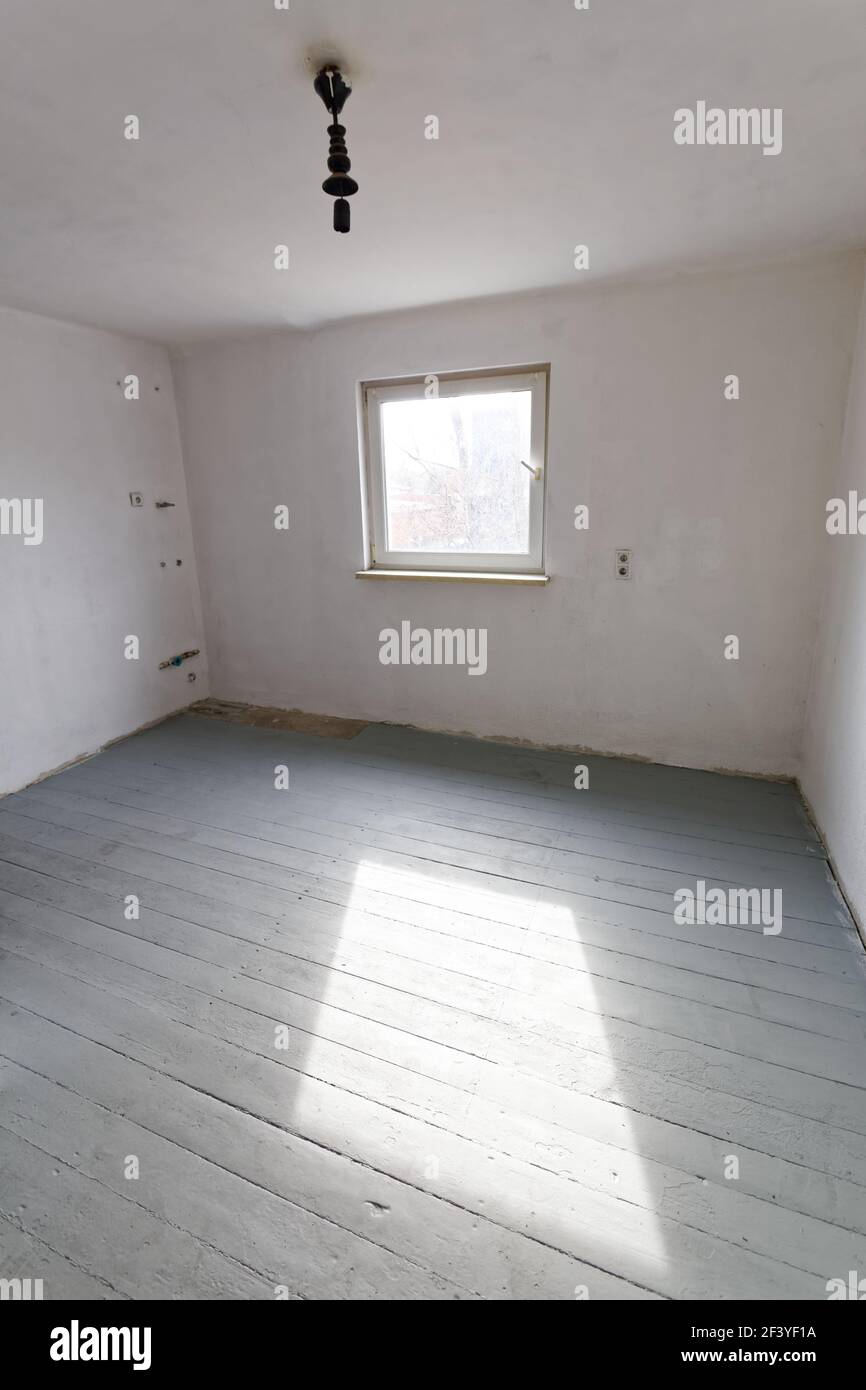 Empty white room of a studio with a window with a patch of light in the ...