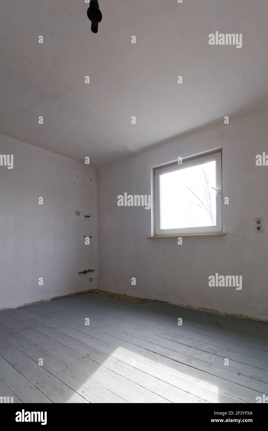 Empty white room of a studio with a window with a patch of light in the ...