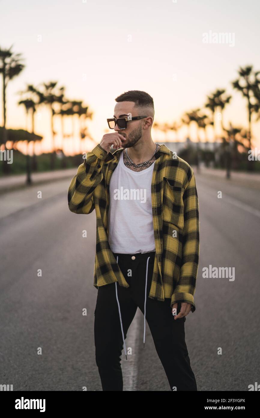 A vertical shot of a handsome Spanish Caucasian man with tattoos and ...