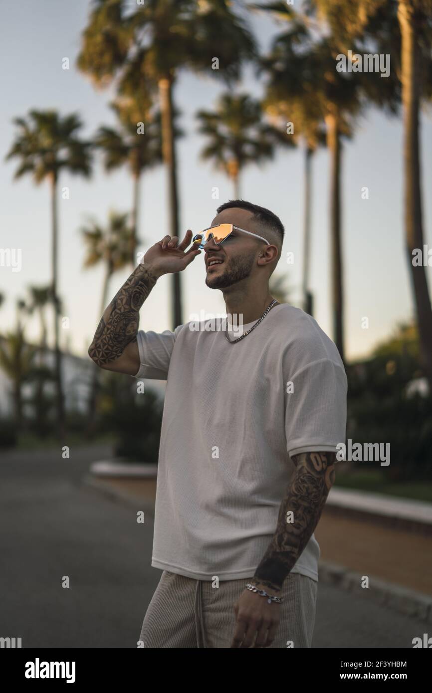 A vertical shot of a handsome Spanish Caucasian man with tattoos and ...