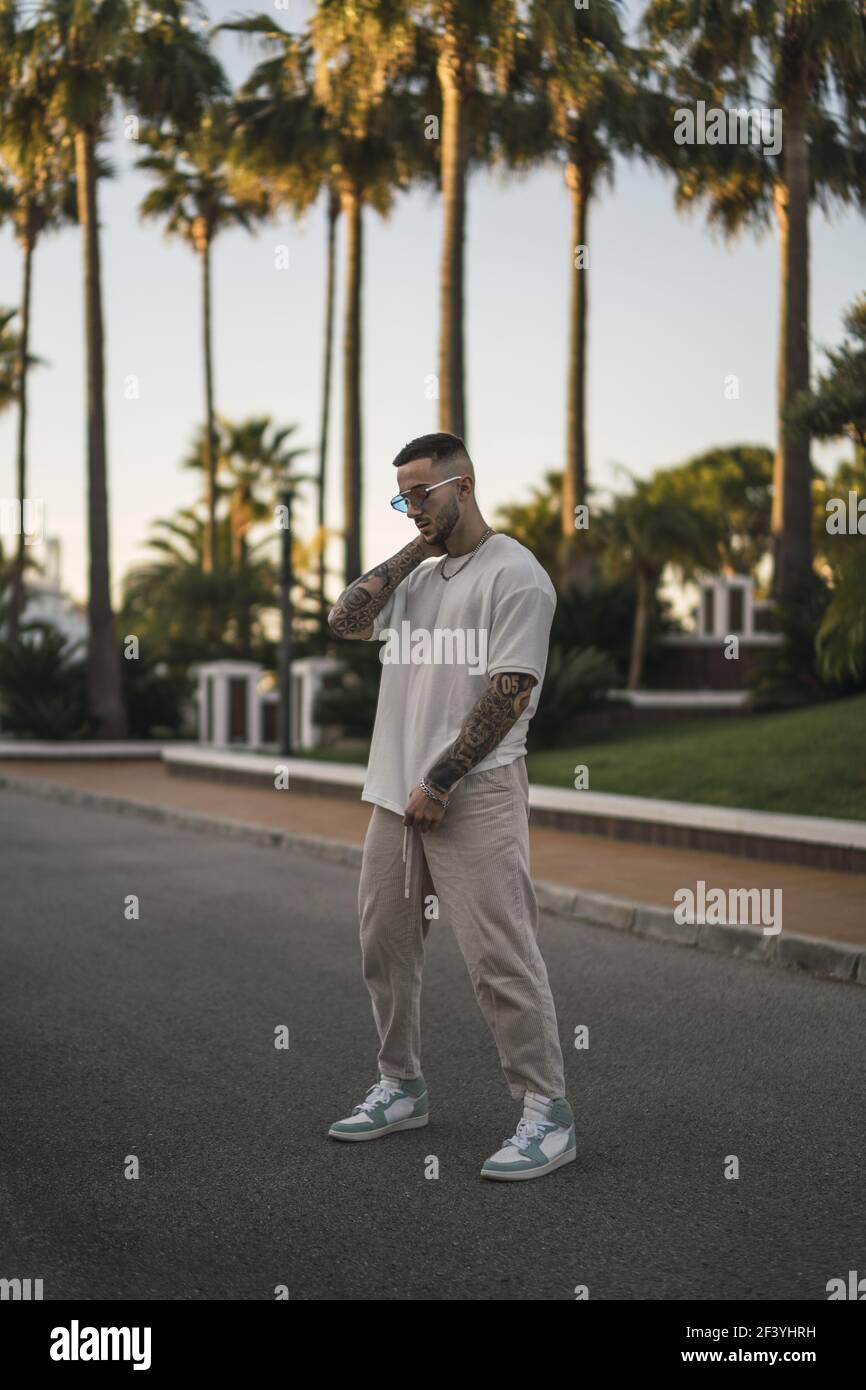 A vertical shot of a handsome Spanish Caucasian man with tattoos and ...