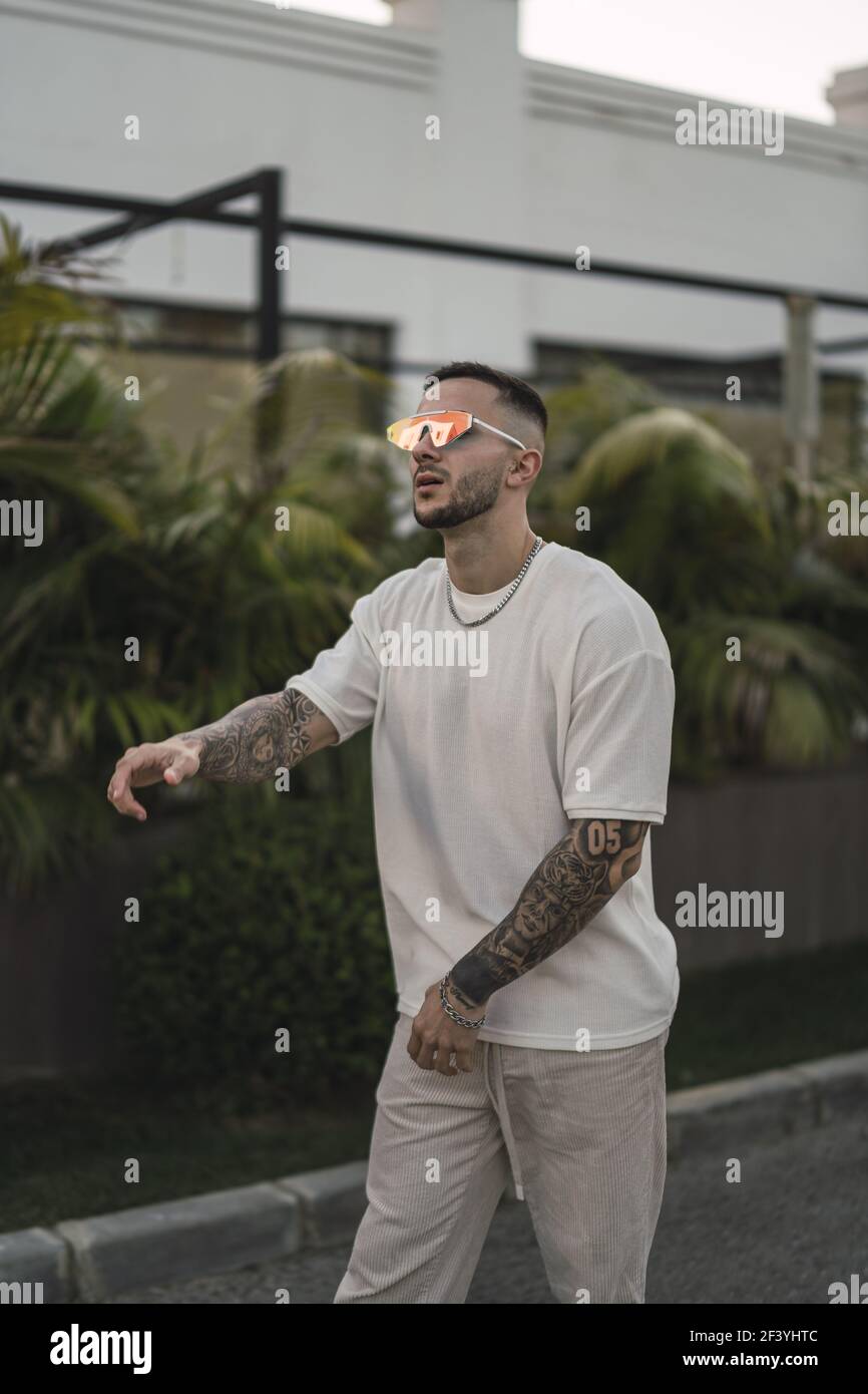 A vertical shot of a handsome Spanish Caucasian man with tattoos and ...
