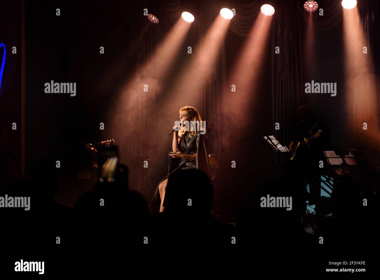 Singer with her band performing on stage. Concert. View from the ...