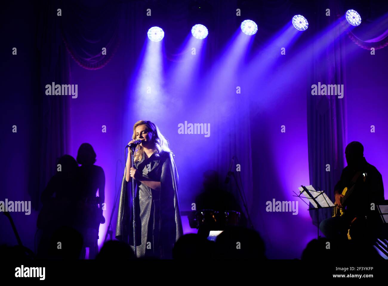 Singer with her band performing on stage. Concert. View from the ...