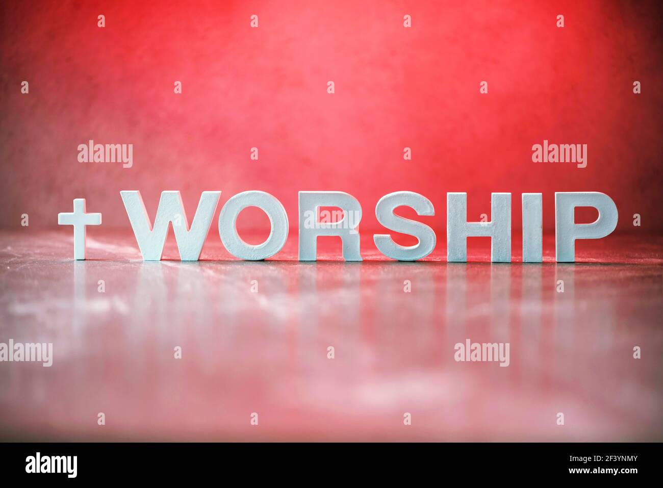 Word Worship made with cement letters on red marble background. Copy ...