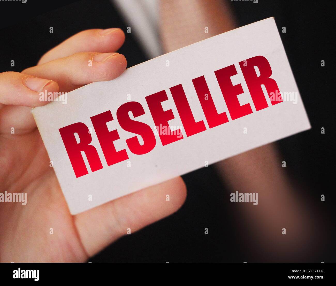 Businessman holding a card with Reseller word. Reselling business ...