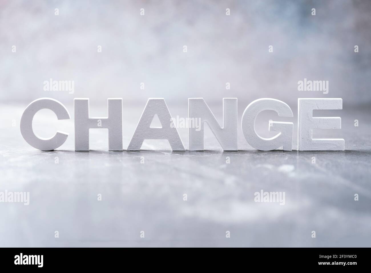 Word change word made with cement letters on grey marble background ...
