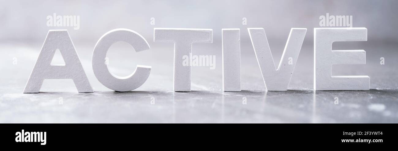 Word ACTIVE made with cement letters on grey marble background. Copy ...