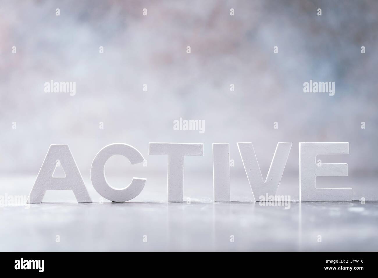Word ACTIVE made with cement letters on grey marble background. Copy ...