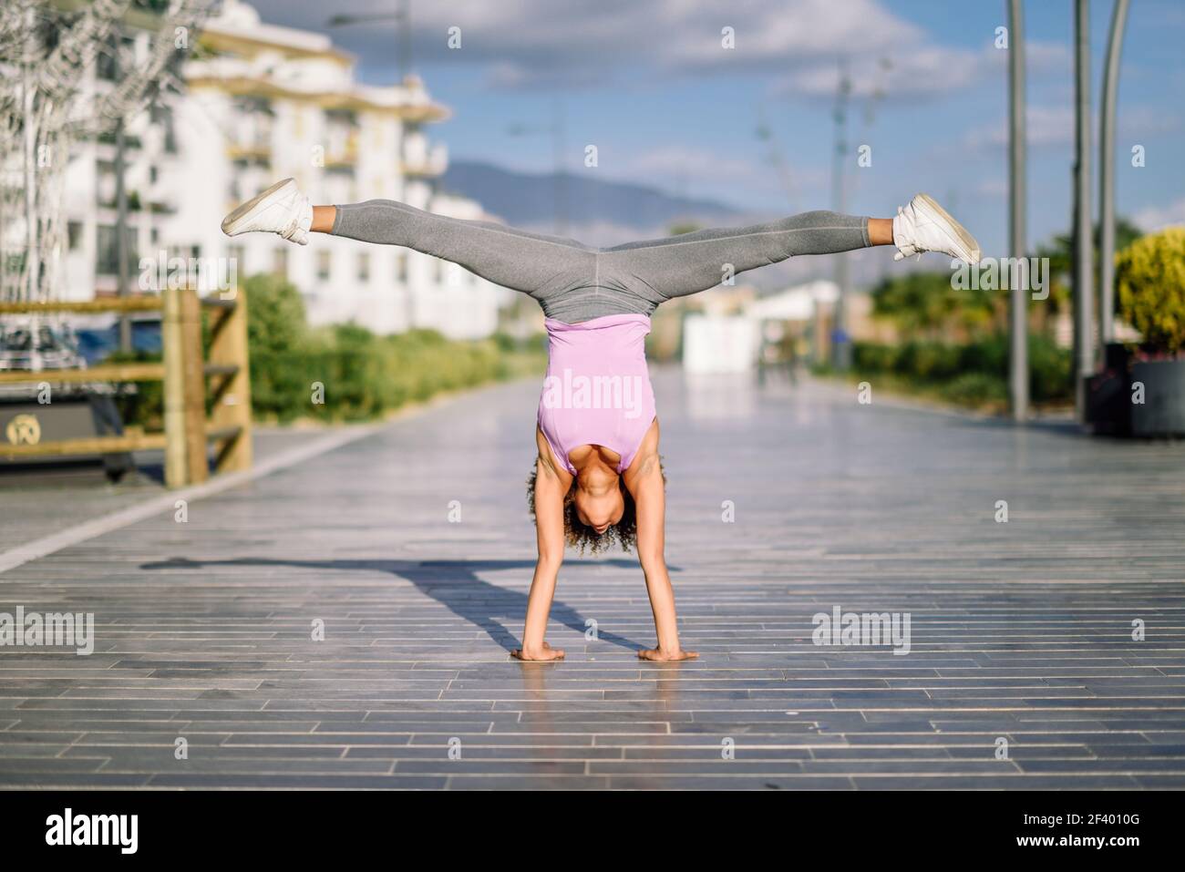 Black fit woman doing fitness acrobatics in urban background. Black fit ...